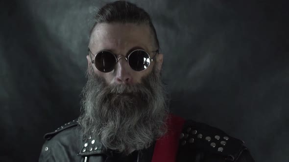 Close up bearded rock musician head with shaved temples wearing round ...