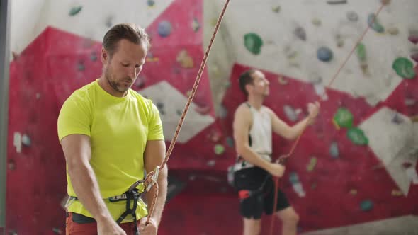 Man Belaying Another Climber on an Indoor Climbing Wall, Stock Footage