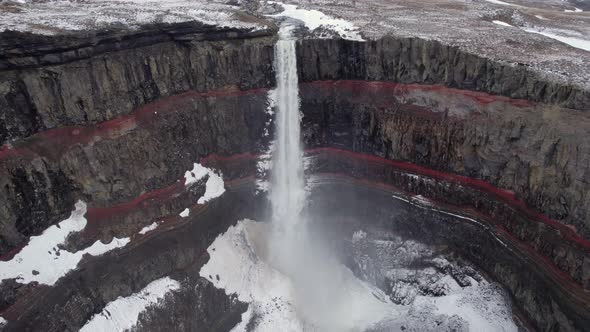 Water crashes down from Hengifoss falls into the frozen basaltic ravine ...