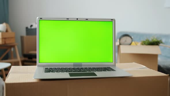 Closeup of Green Chroma Key Screen Laptop on Cardboard Box in New House ...