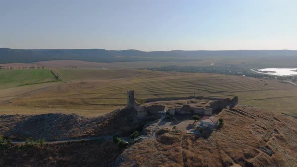 Long drone tracking shot of Enisala, medieval fortress on top of a hill ...