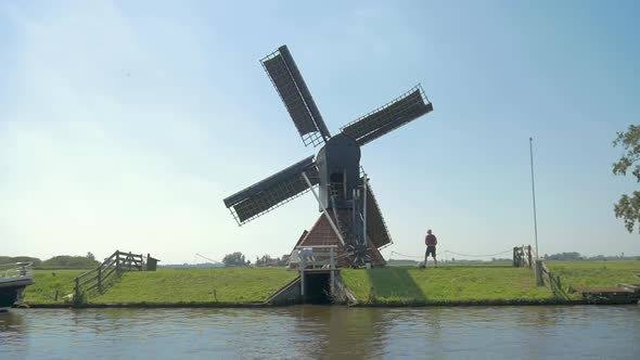 Dutch Old Windmill on a dike near the water, a small Dolly shot in ...