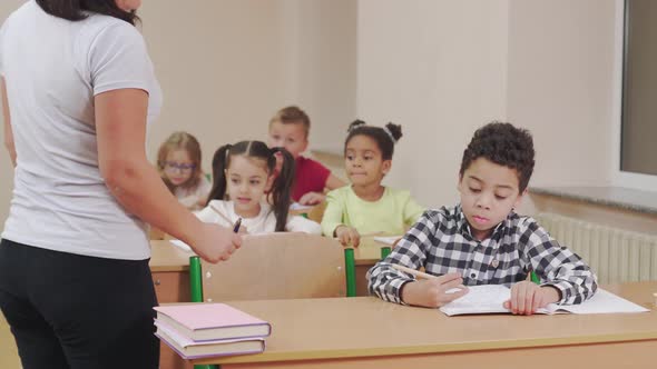 Teacher Checking Copybook of Pupil in Classroom., Stock Footage | VideoHive