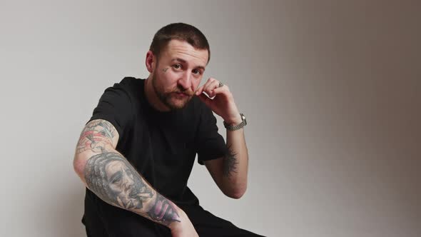 Darkhaired Bearded Millennial Touches His Moustache and Covers His Face ...