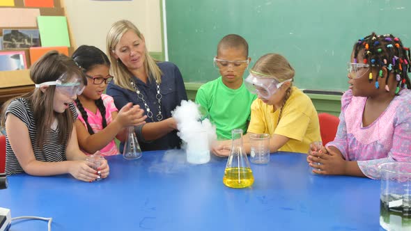 Teacher and students doing science experiment in school classroom ...