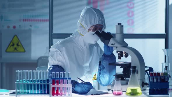 Virology Researcher Using Microscope and Taking Notes, Stock Footage