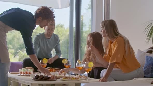 Four People Talking, Eating and Drinking Cocktail. Happy Hour at home ...