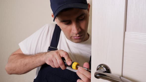 Portrait of Young Locksmith Workman in Blue Uniform Installing Door ...