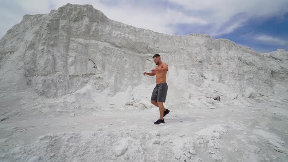 Shirtless bodybuilder in white mountains. Strong man with muscular body ...