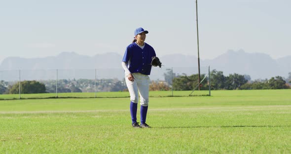 Caucasian female baseball player, fielder jumping and catching ball on ...
