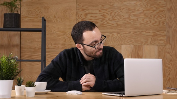 Guy in front of a monitor laptop watching video and reacts, Stock Footage