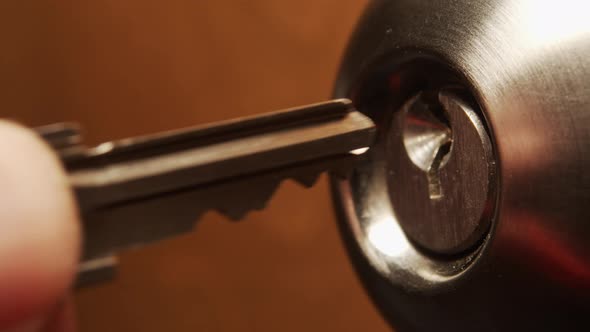 Macro shot of a silver key inserted into lock of an internal doorknob ...