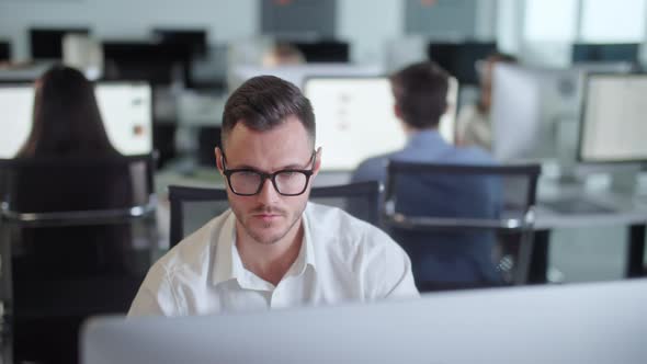 Serious Young Man Working on Decktop Computer While Working in Big Open ...