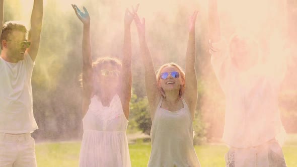 Cheerful Young People Throwing Up Colorful Powder and Hugging at Summer ...