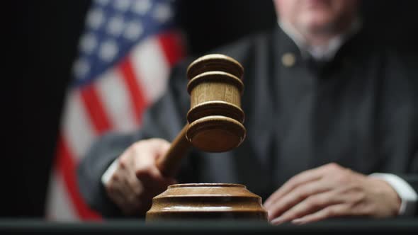 Judge's Hand With Wooden Gavel Hammering Against American Flag In ...
