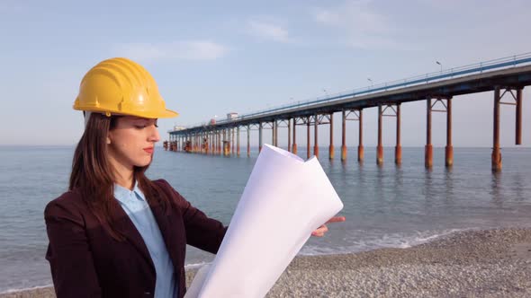 Female Engineer is Walking on the Beach near the Bridge, Stock Footage