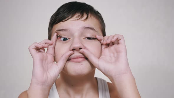 Positive Child Touches His Face with His Hands Grimaces Looking at the ...