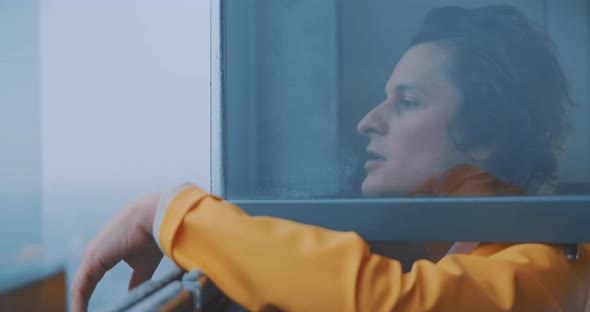 Young man looking out of window with his hands reaching outside, Stock ...