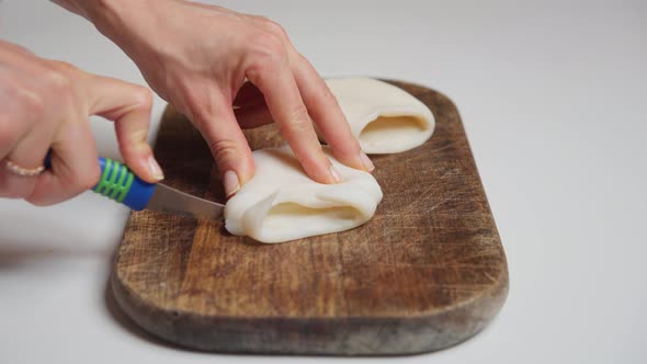 Woman Chef Cutting Squid Raw Calamari Into Rings on a Wooden Cutting ...