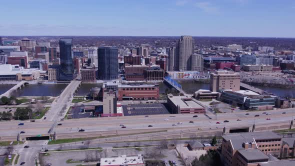 Wide aerial pan of trafficked highway, river and Grand Rapids skyline ...