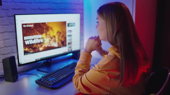 Girl using computer at home. Young woman watching video on computer in ...