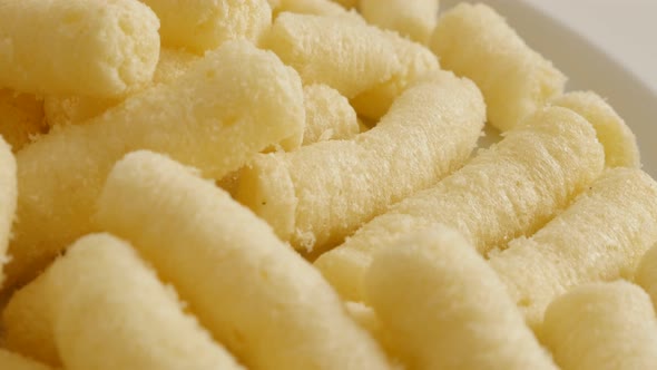 Close-up of corn flips puffs unhealthy food background slow tilt 4K ...