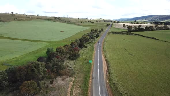 Drone Shot Of Car Driving Off Into Distance Along Straight Country Road ...
