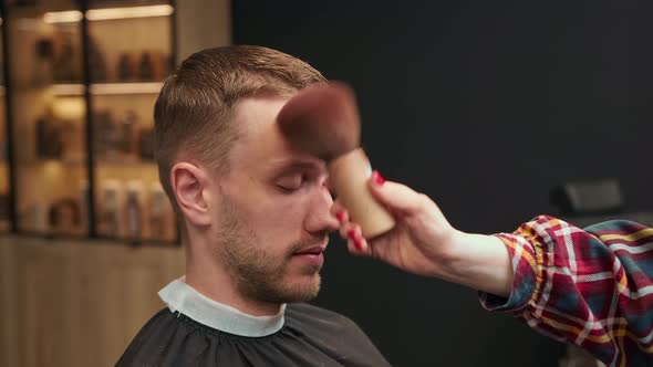 Barbershop: woman barber shakes off cut hair while cutting a man, Stock ...