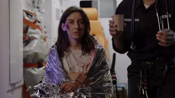Injured Woman Receiving Cup of Tea From African Paramedic, Stock Footage