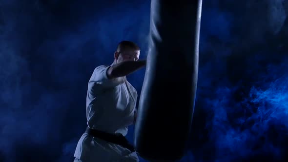 Silhouette Karate Man Practicing on the Sandbag on Blue Background ...