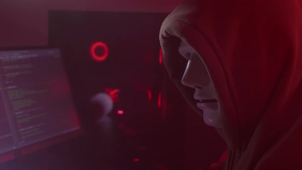 Anonymous Person in a White Mask Works on the Computer Inputs Code ...