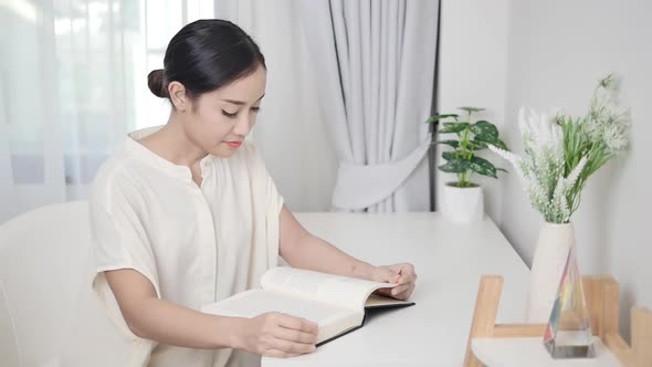 A freelance translator using a laptop sits on a kitchen table in self ...
