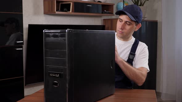 Closeup of a Male Handyman in Overalls Repairing a Computer at a Client ...