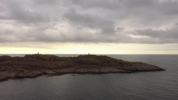 Approaching Ryvingen island and lighthouse - Sunset aerial with ...