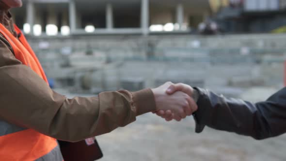 Friendly handshake of two builders at a construction site, Stock Footage