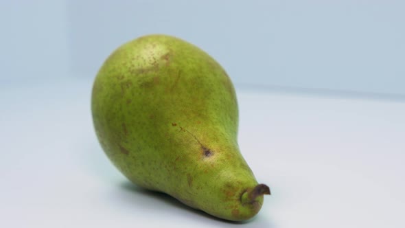Fresh big green pear rotates slowly on a light blue background, healthy ...