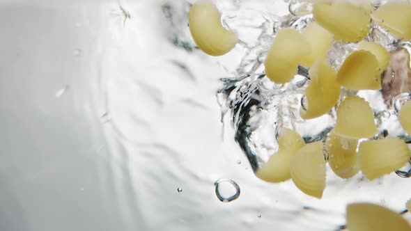Cavatappi Pasta Falls Down Into Water with Bubbles on White, Stock Footage