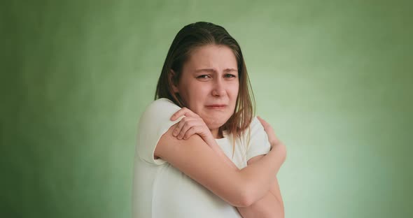 Unhappy Scared Lady Hugs Herself Trying to Protect on Green, Stock Footage