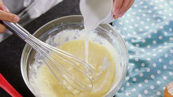 Woman adding milk to beaten eggs in a bowl, Stock Footage | VideoHive