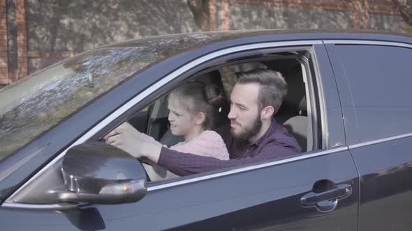 Little Girl Sitting on Father's Lap in Car Close Up. The Child Is ...