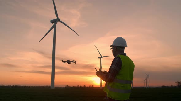 Windmill Engineer Watching the Operation of Wind Turbines with a Drone ...