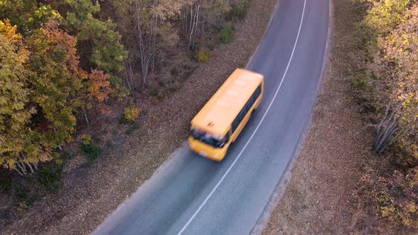 road with school bus in beautiful autumn forest at sunset., Stock Footage