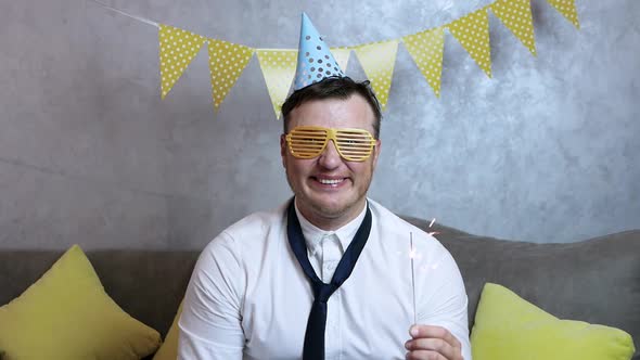 Funny Young Man With A Sparkler In His Hands In A Festive Hat, Shirt ...