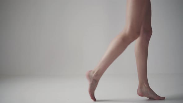Female Legs. Girl Walks on Tiptoes Barefoot on a White Background ...