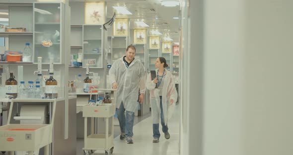 Scientists walking in halls of a pharmaceutical lab by TheStockStudio