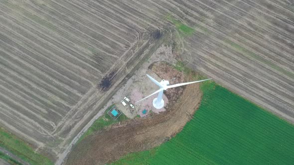 Overhead slow descent wind turbine in ploughed field, Stock Footage