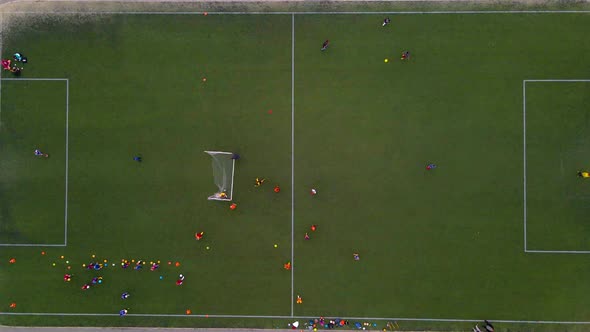 Aerial view above a soccer field, while people play football, in a poor ...