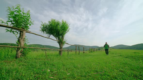 A Tourist with a Backpack Walks Along the Pathin the Background of the ...