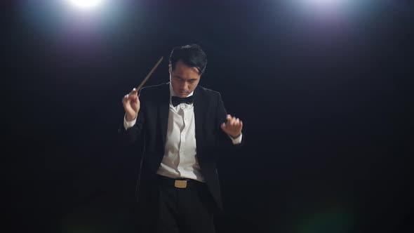 Asian Conductor Man Holding A Baton Closing His Eyes And Showing ...