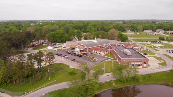 Establishing side view of red brick hospital building, reflective small ...